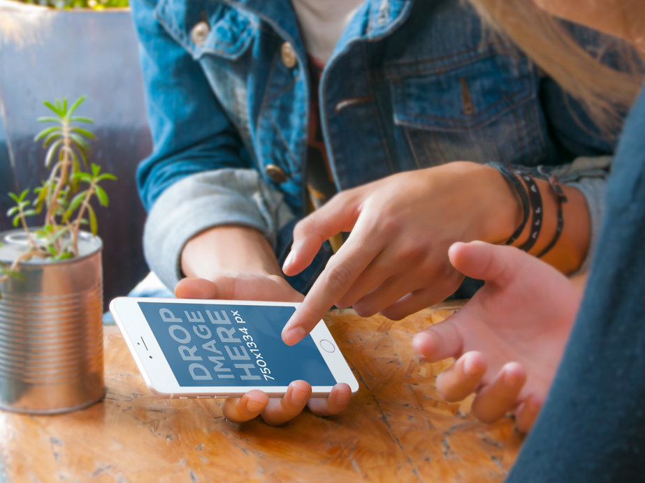 Placeit - Mockup of Two Friends Looking at an iPhone 6