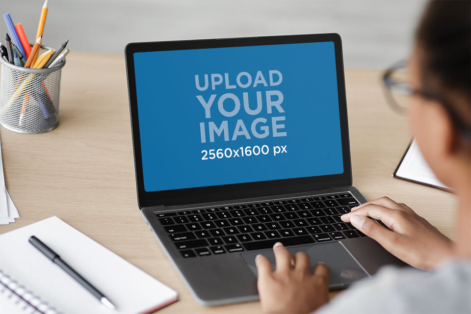 Placeit - MacBook Mockup Featuring a Young Student Doing Homework