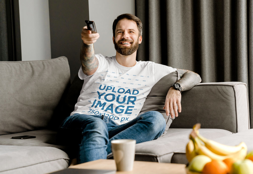Placeit - T-Shirt Mockup Featuring a Man Smiling While Watching TV