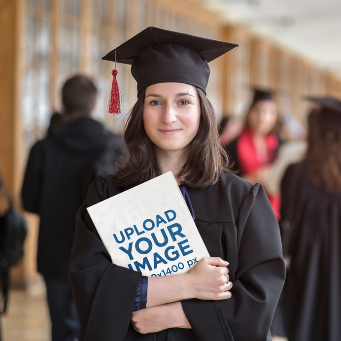 Placeit - Mockup of a Female Graduate Holding a Hard-Cover Book