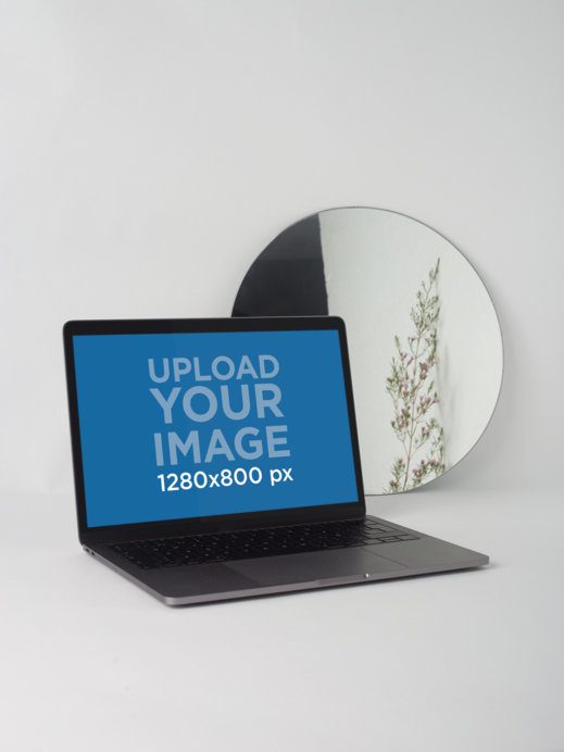 Placeit - MacBook Pro Mockup on a White Surface Near a Round Window