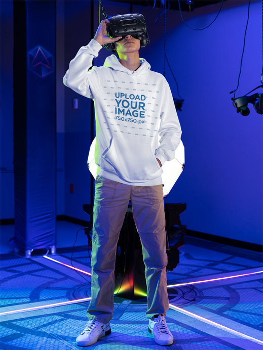 Placeit - Mockup of a Gamer Wearing a Hoodie at a VR Gaming Arena