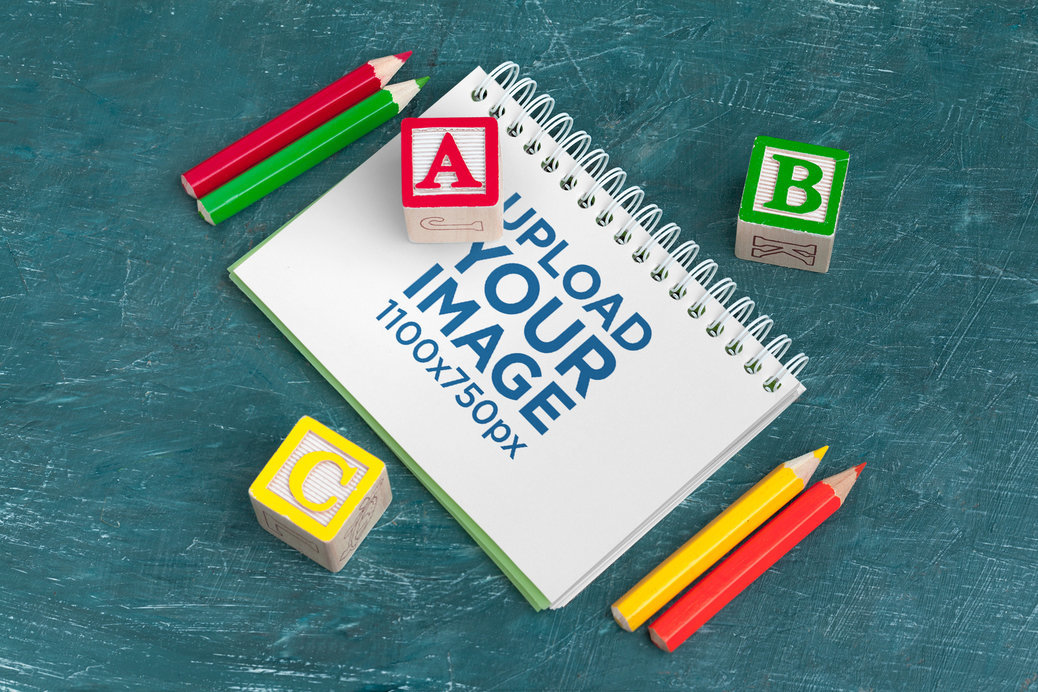 Placeit - Mockup of a Notebook Featuring Abecedary Cubes and Pencils