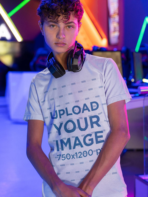 Placeit - T-Shirt Mockup of a Gamer Posing at a Gaming Arena