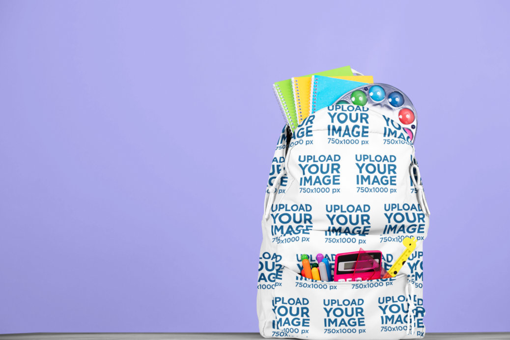 Placeit - Mockup of a Sublimated Backpack with Notebooks and School Items