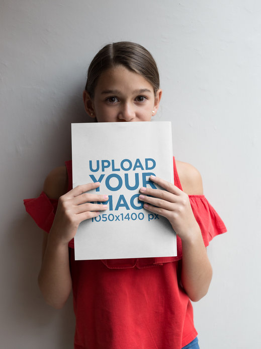 Placeit - Happy Girl Holding her New Book Mockup Against a White Wall