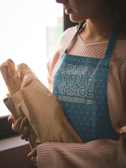 Placeit - Apron Mockup Featuring a Woman Holding a Bag of Bread