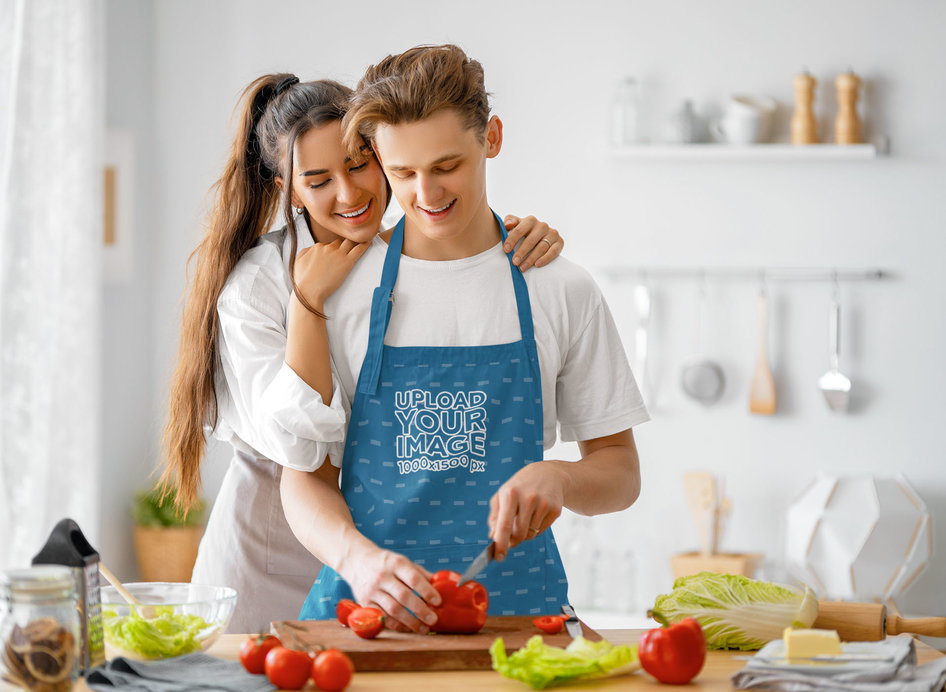 Placeit - Apron Mockup Featuring a Happy Man Cooking With His Girlfriend