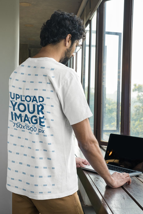 Placeit - Back-View Mockup Featuring a Man Standing in Front of His Laptop