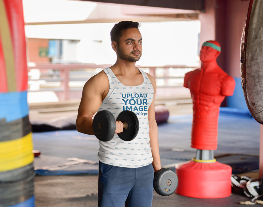 Placeit - Tank Top Mockup of a Fitness Man Lifting Weights at the Gym