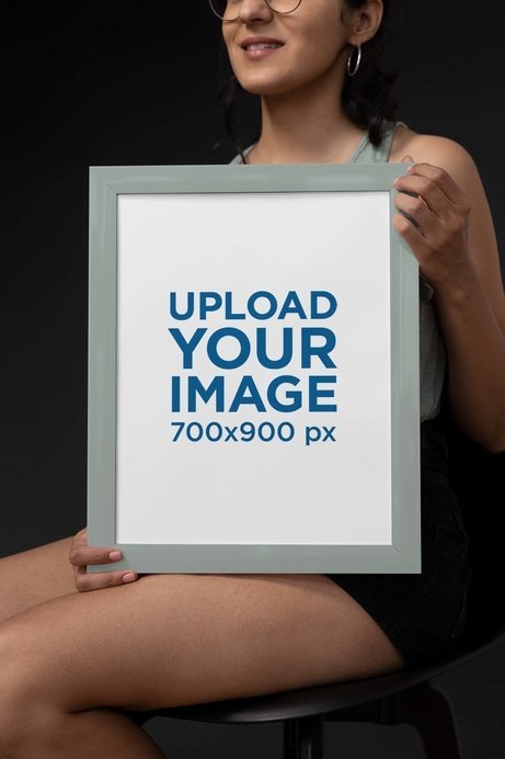 Placeit - Mockup of a Smiling Cropped-Face Woman Holding a Photo Frame