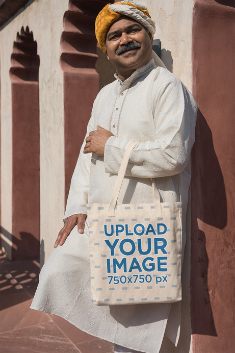 Placeit - Tote Bag Mockup Featuring a Smiling Man in a Traditional Attire