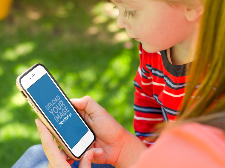 Placeit - Mockup of a Little Boy Looking at an iPhone