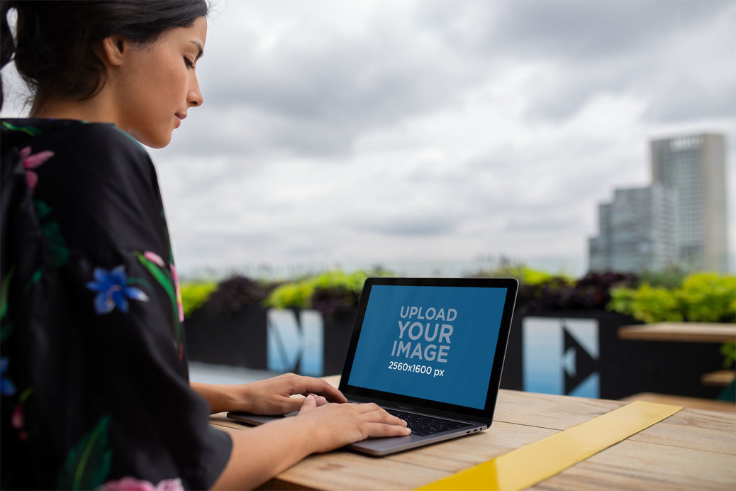 Placeit - Woman Working with MacBook Pro Mockup on a Terrace