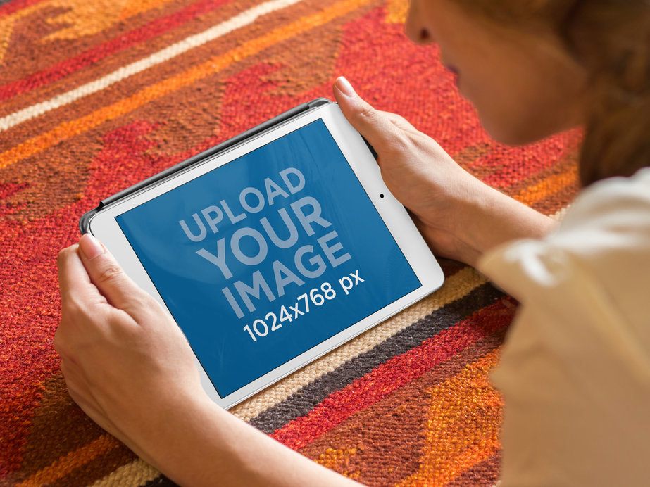 Placeit - Mockup of Woman Using White iPad Laying On the Carpet