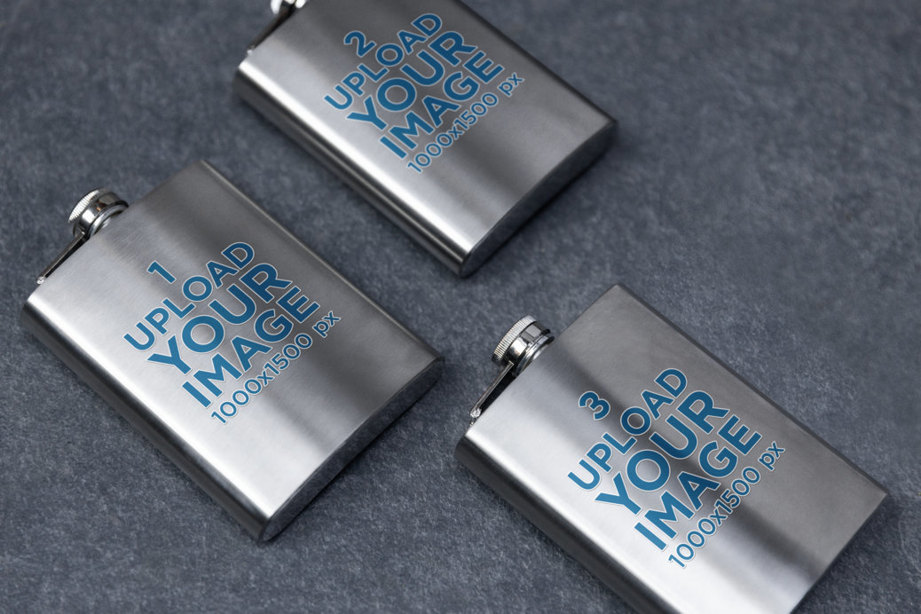 Placeit - Mockup of Three Aluminum Flasks Placed Face-Up on a Solid Surface