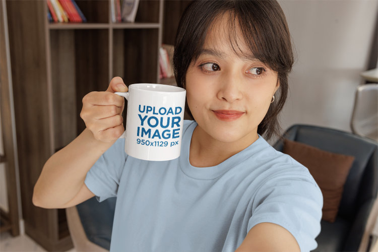 Placeit - Mockup of a Woman Taking a Selfie While Holding Her Coffee Mug