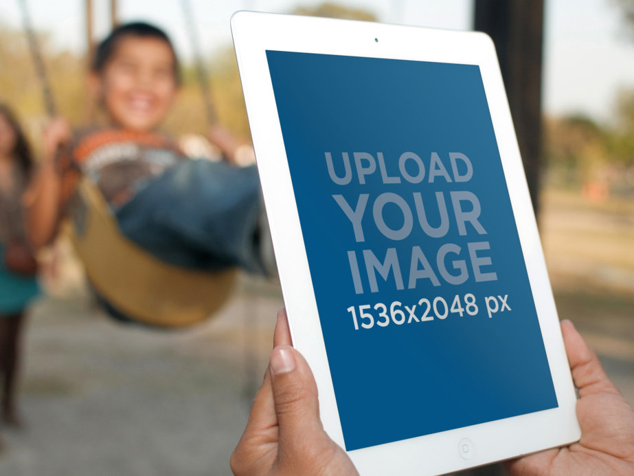 Placeit - Mockup of a White iPad Featuring a Kid in a Swing