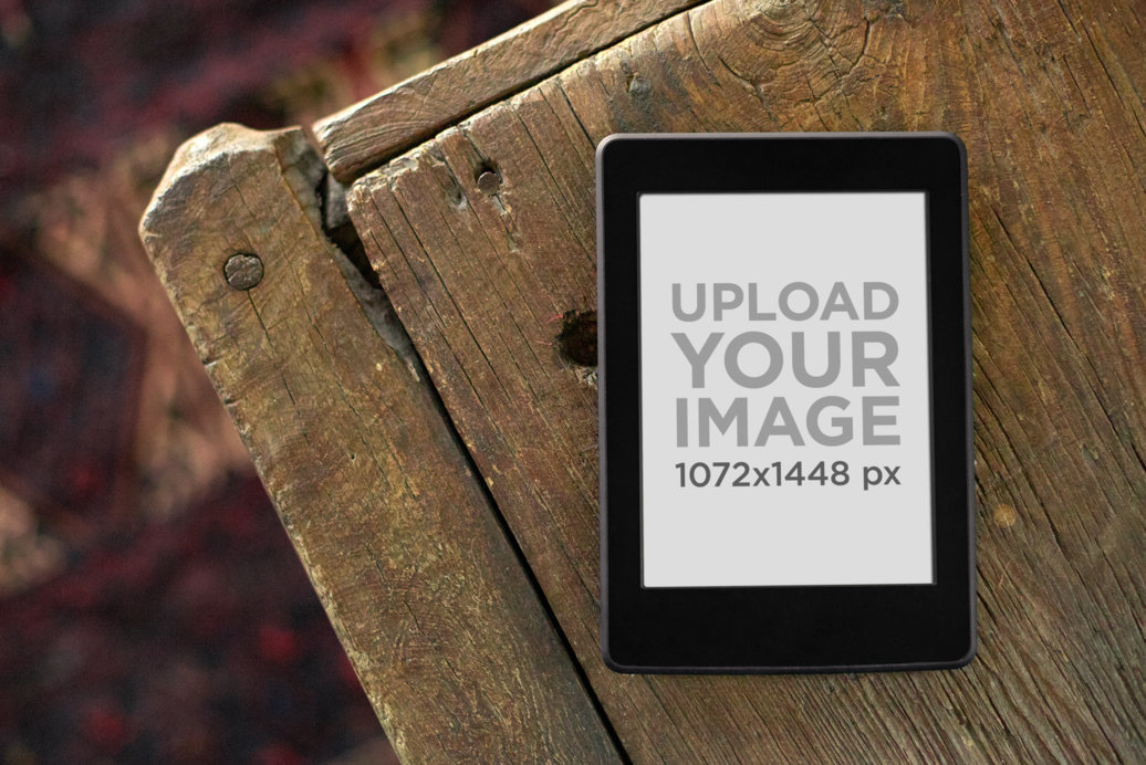 Placeit - Mockup of a Kindle Paperwhite on the Corner of a Wooden Table