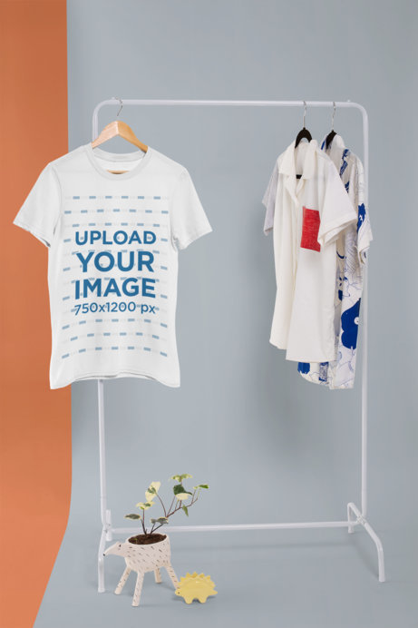 Placeit - T-Shirt Mockup Hanging from a Rack Along with Other Garments