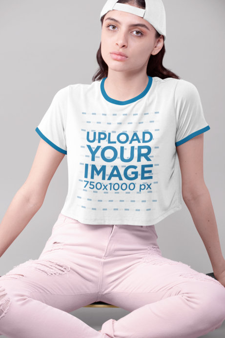 Placeit - Crop Top Ringer Tee Mockup Featuring a Woman Sitting in a Studio