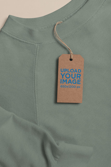 Placeit - Mockup of a Cardboard Clothing Tag Lying on a Sweater