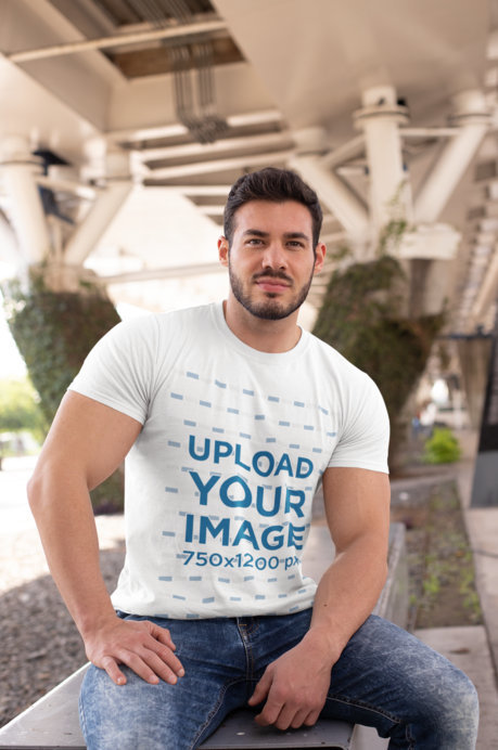 Placeit - T-Shirt Mockup of a Muscular Man Sitting on a Bench in the City