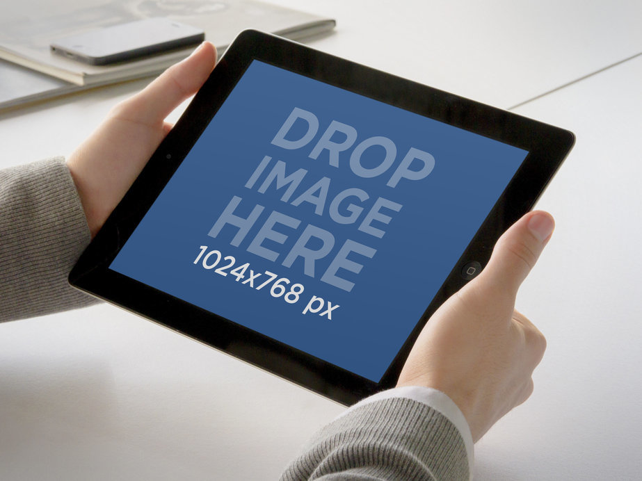 Placeit - Mockup of Someone Holding an iPad Over a Desk