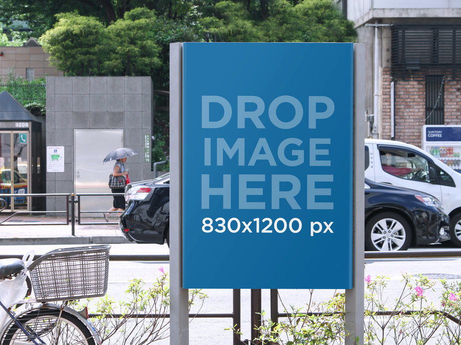 Placeit - Vertical Banner Mockup on a Sidewalk at a Busy Street