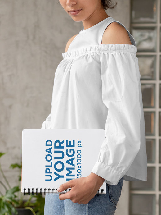 Placeit - Mockup of a Woman Holding a Spiral Notebook
