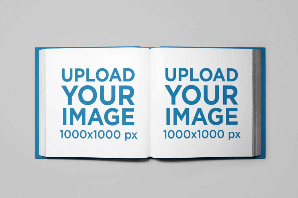 Placeit - Mockup of an Open Square Book Displayed on a Solid Surface