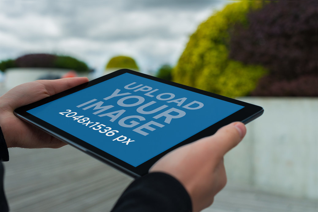 Placeit - Mockup of a Man Holding an iPad in Landscape Position