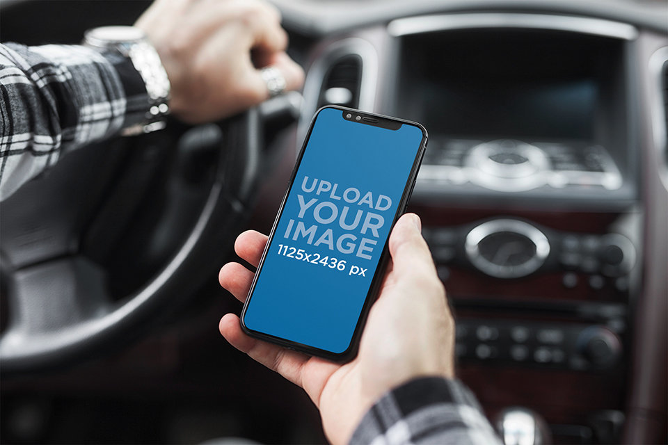 Placeit - Mockup of a Man Holding an iPhone 11 Pro in His Car