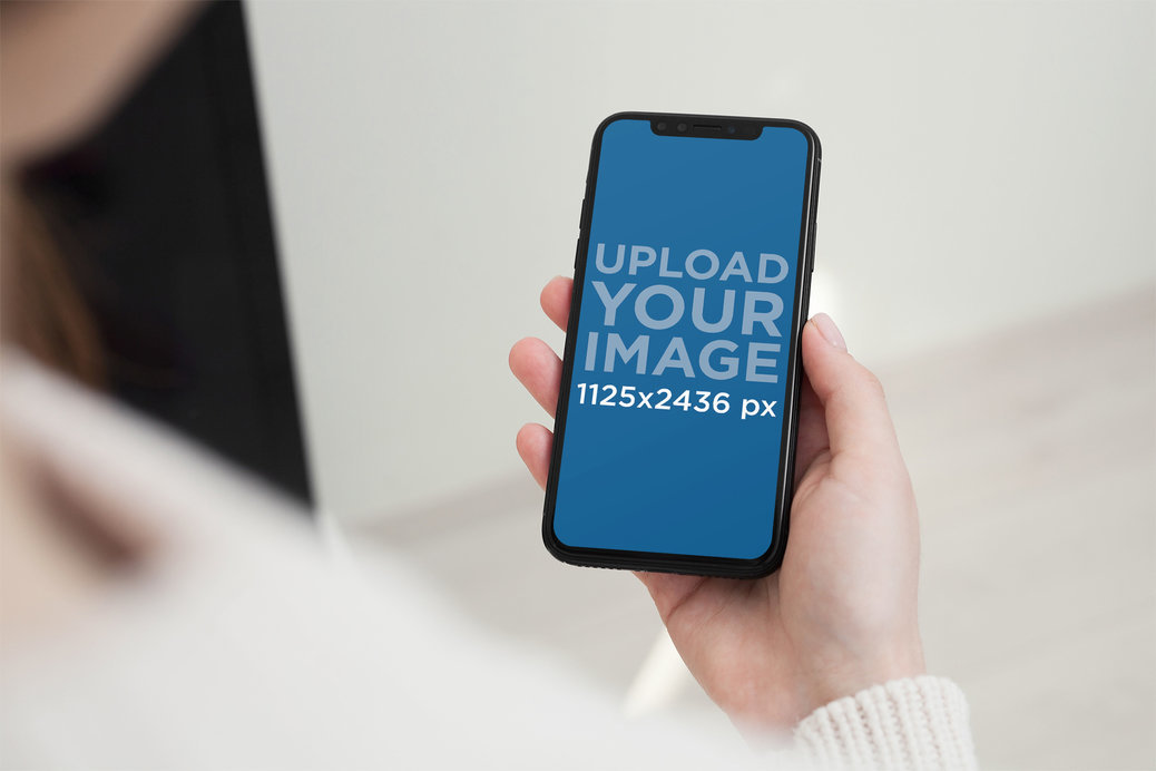 Placeit - Mockup of a Woman Holding an iPhone 11 Pro in Portrait Position