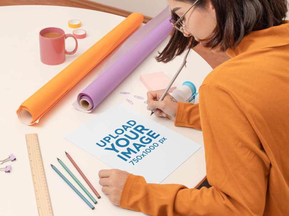 Placeit - Mockup of a Woman Writing on a Sketch paper