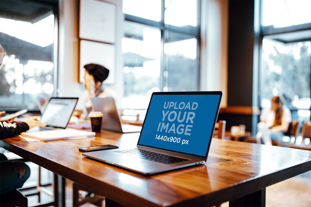 Placeit - Mockup of a Macbook Pro on a Table at a Coffee Shop