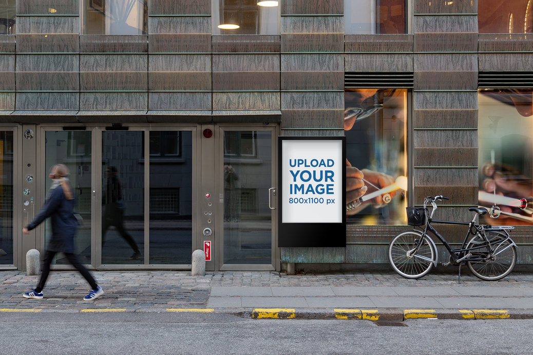 Placeit - MUPI Mockup Featuring a Modern Building and a Person Passing By
