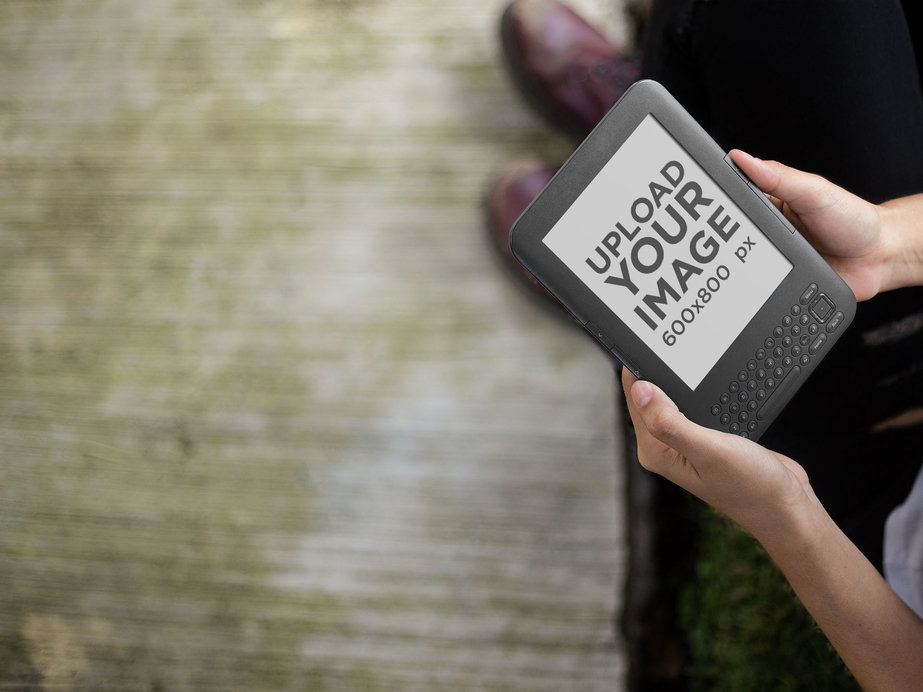 Placeit - Young Man Holding a Kindle Outside Mockup