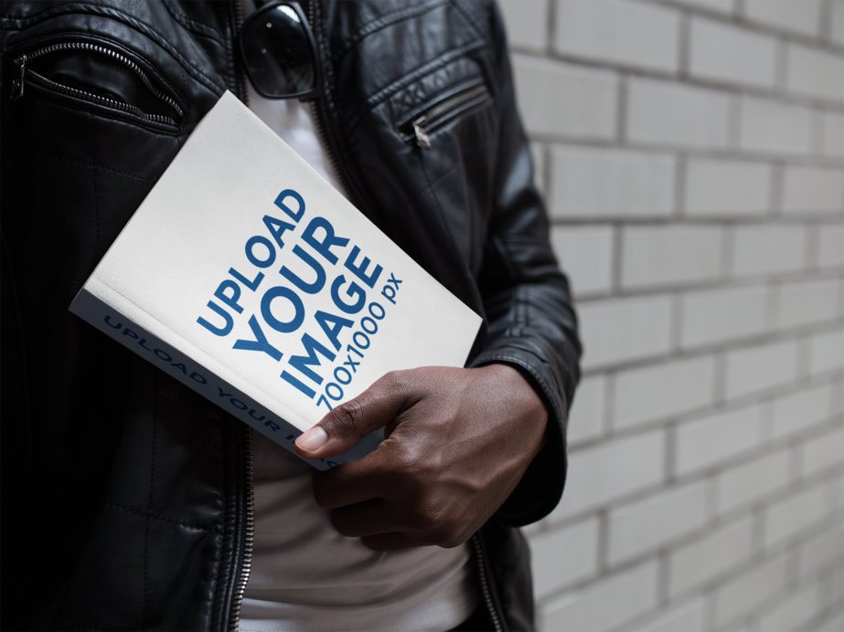 Placeit - Paperback Book Cover Mockup Held by a Young Man