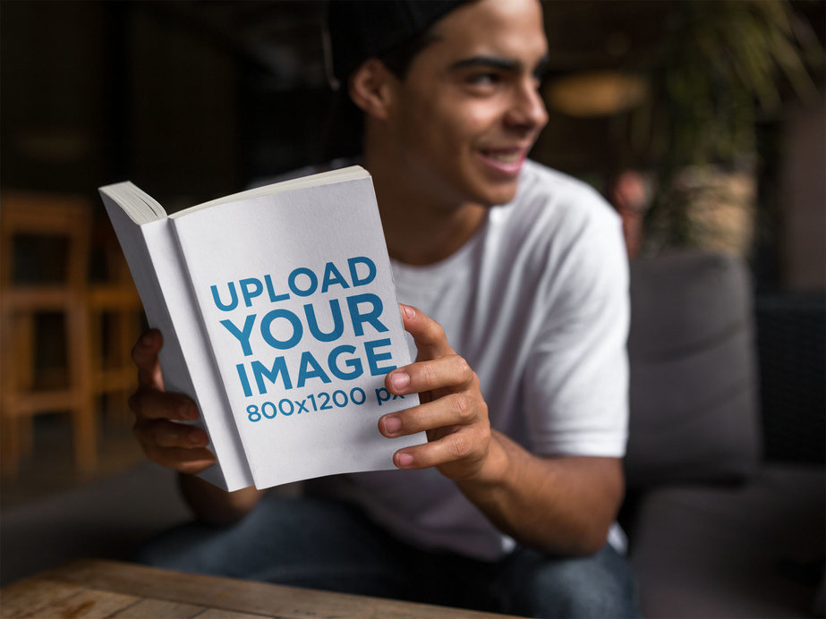Placeit - Young Man Reading His Paperback Book Mockup