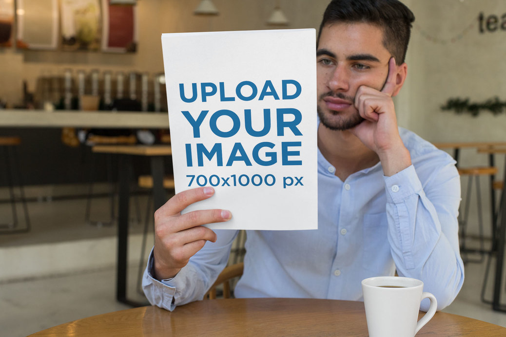 Placeit - Mockup of a Man Reading a Magazine at a Coffee Shop
