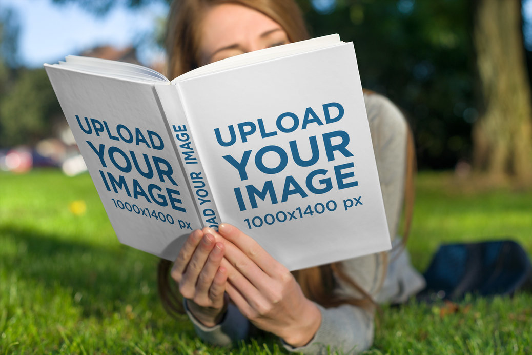 Placeit - Mockup of a Woman Reading a Paperback Book on the Grass