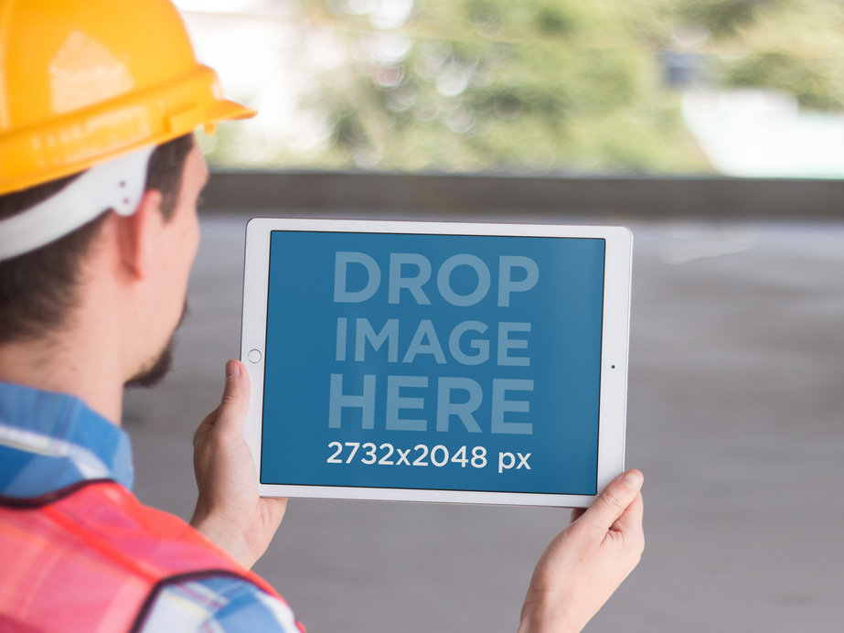 Placeit - iPad Pro Mockup Held in Landscape Position by a Construction ...