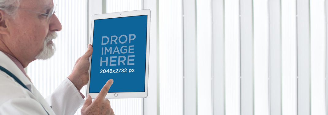 Placeit - Senior Doctor Holding an iPad Pro at a Hospital Mockup