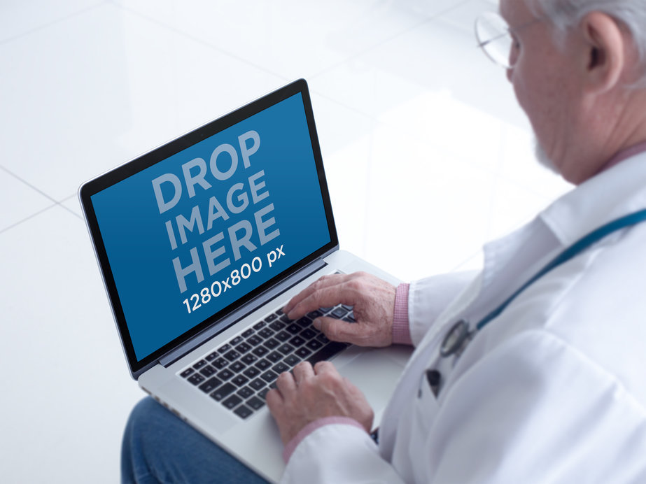 Placeit - Mockup Featuring a Senior Male Doctor Writing in a MacBook