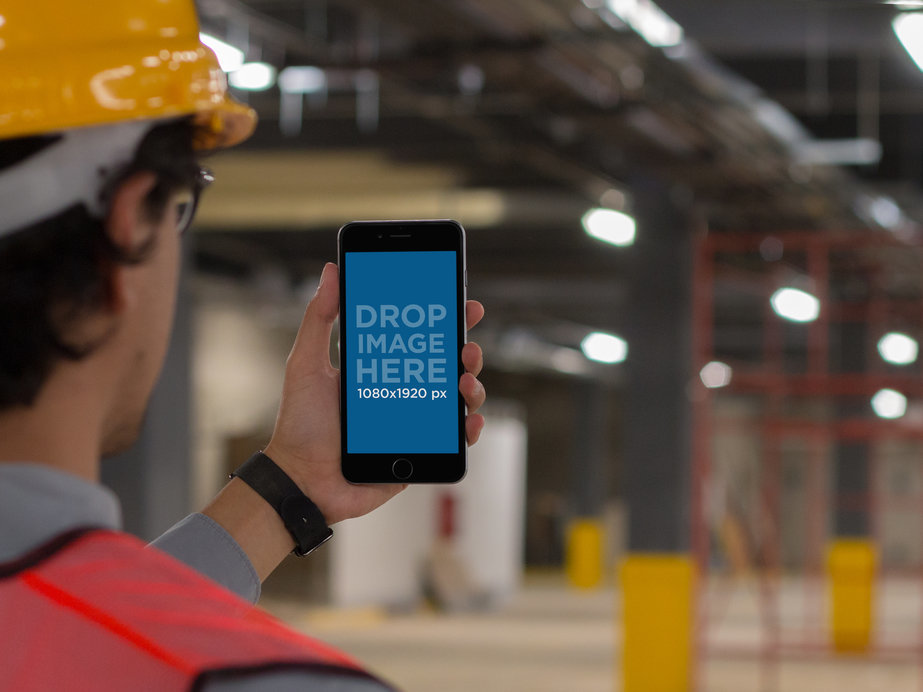 Placeit - Mockup Featuring a Male Worker Staring at an iPhone Inside a ...