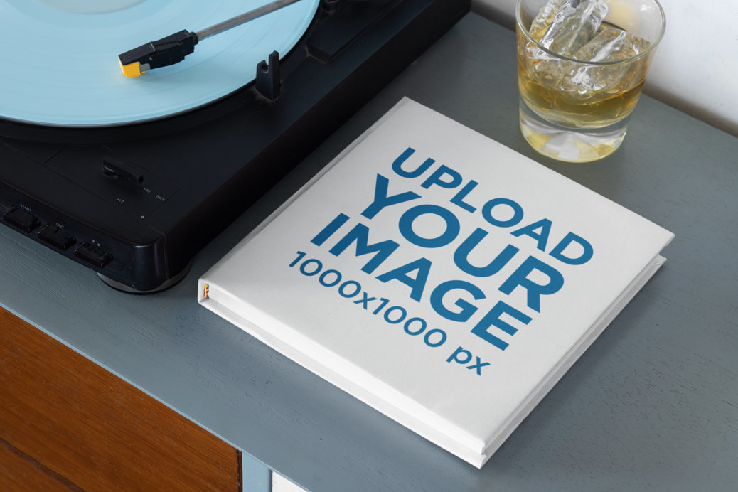 Placeit - Mockup of a Squared Book Next to a Record Player