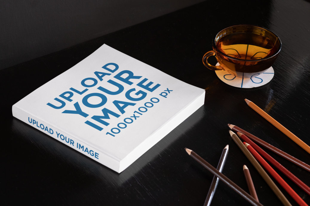 Placeit - Mockup of a Square Paperback Book Placed on a Dark Surface by ...