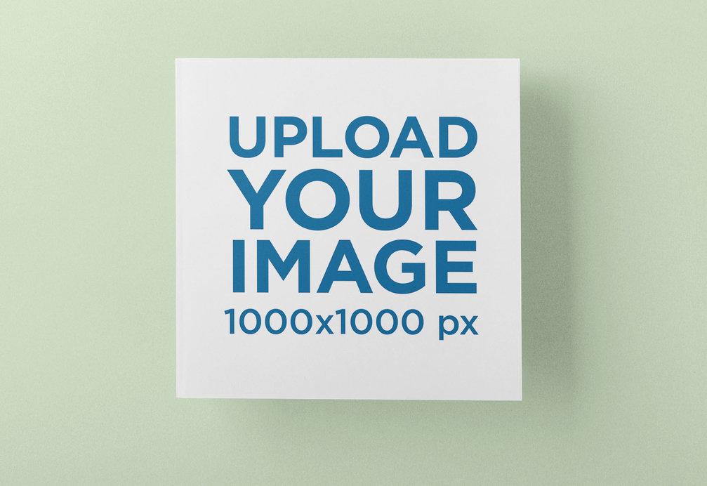 Placeit - Mockup of a Square-Sized Paperback Book Against a Solid Surface