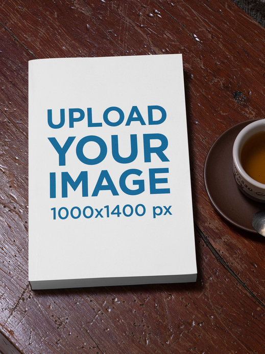 Placeit - Mockup of a Paperback Book Placed on a Wooden Table